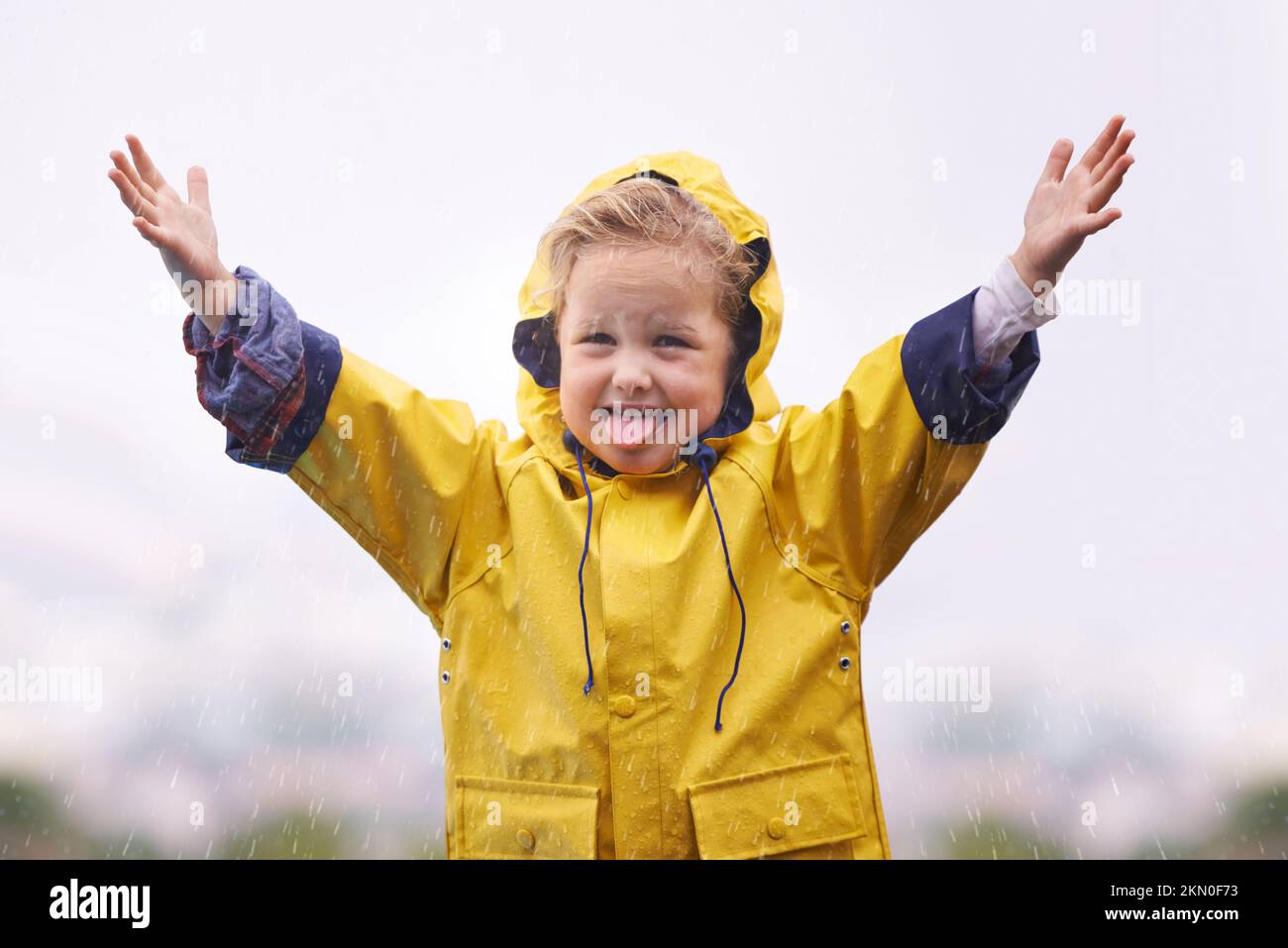 Finding the fun in rain. an adorable little girl playing outside in the ...