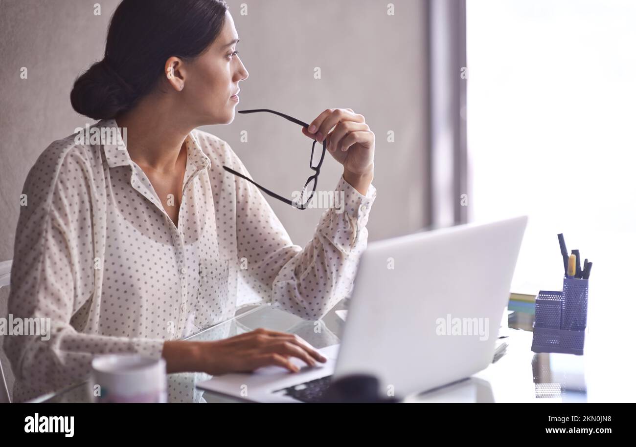 Hard work ensures success. a beautiful young business woman thinking at ...
