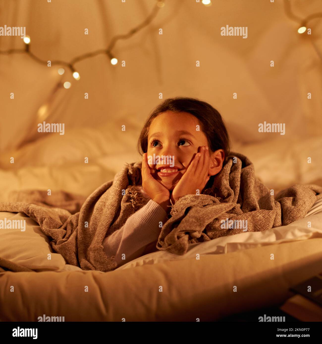 Im having my own sleepover. a happy little girl lying on her bed Stock ...