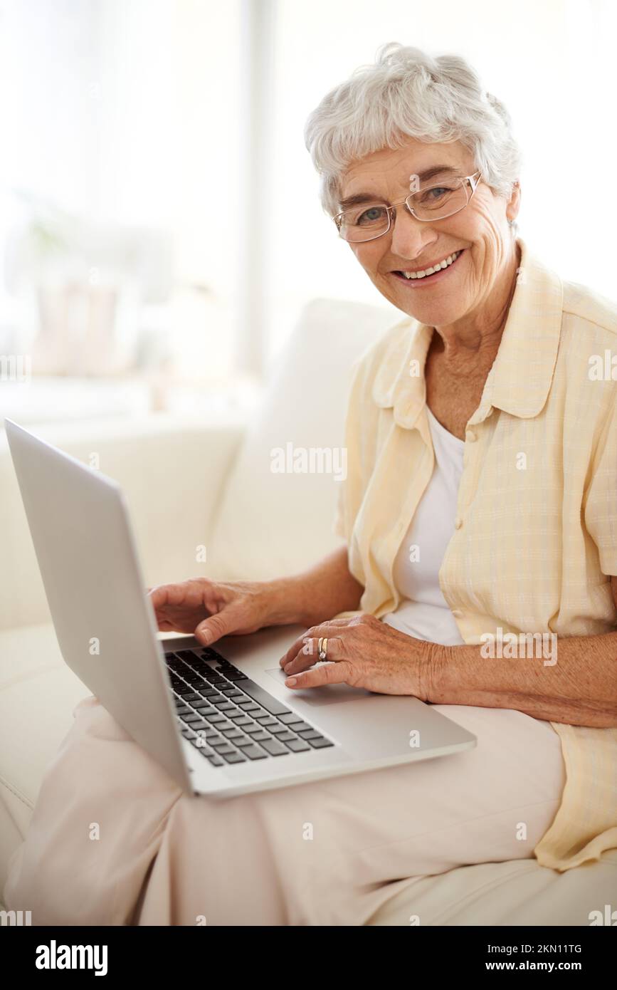 Keeping her blog followers happy. An aged woman working on a laptop ...