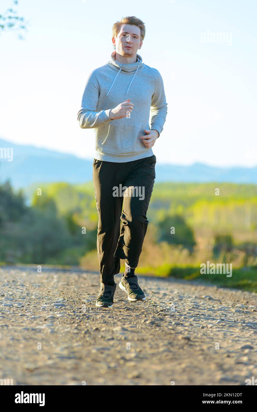 Running man jogging in rural nature at beautiful summer day. Sport ...