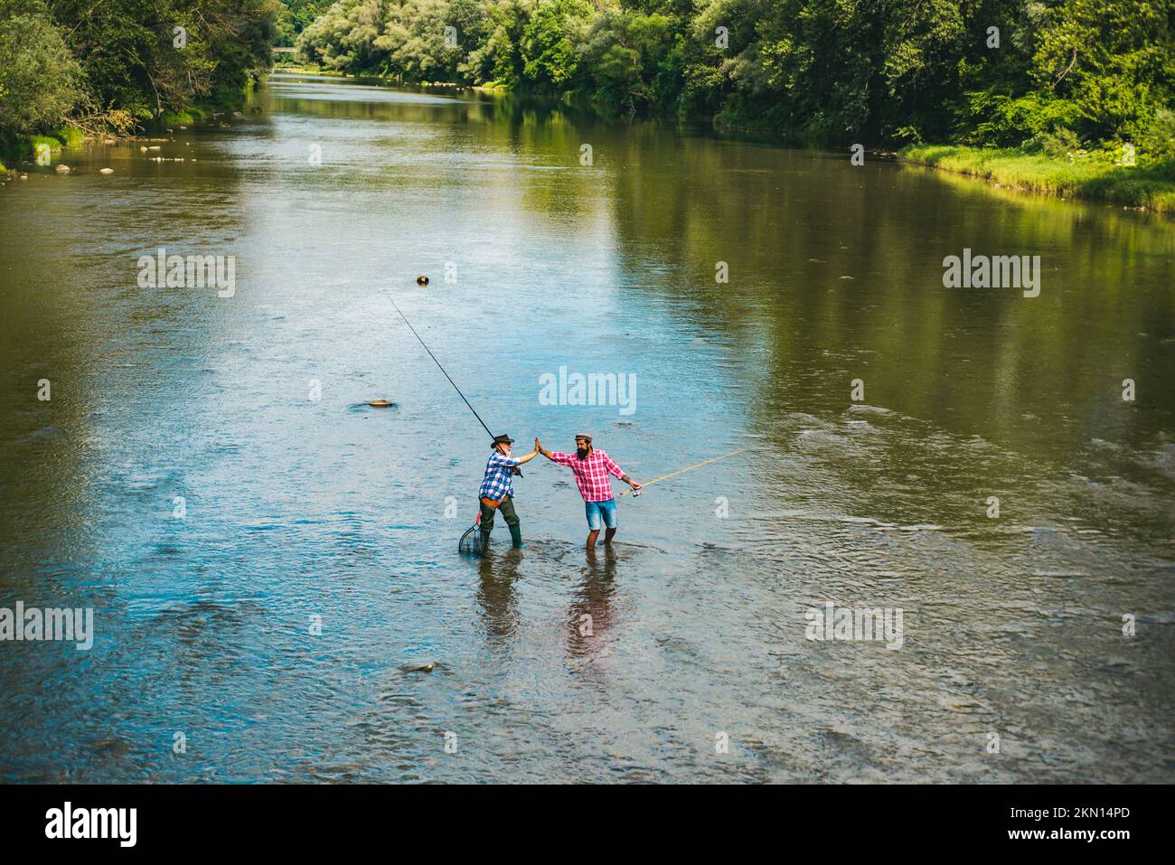 Two men friends fishing. Flyfishing angler makes cast, standing in ...