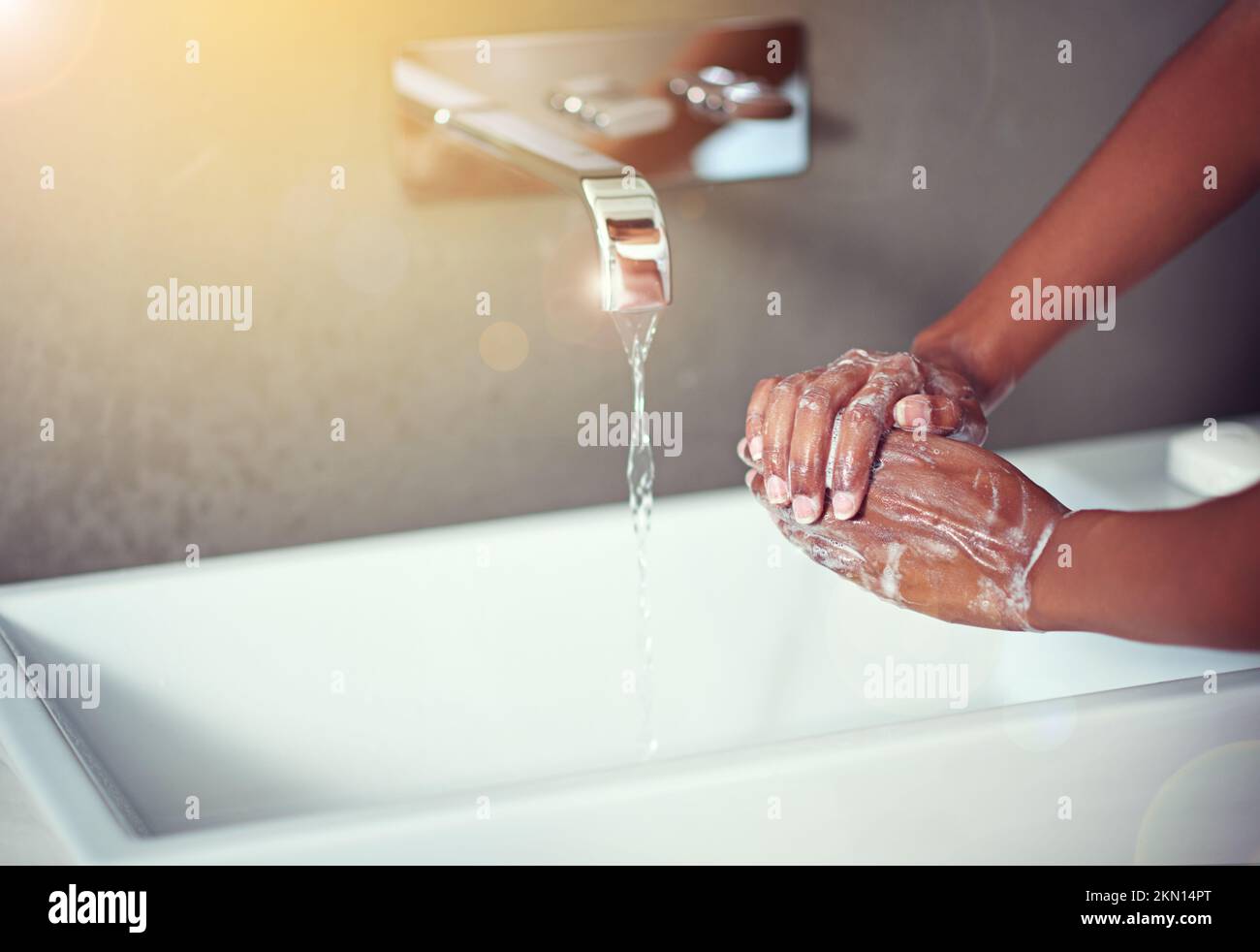 Keeping her hands clean. an unrecognizable woman washing her hands in ...