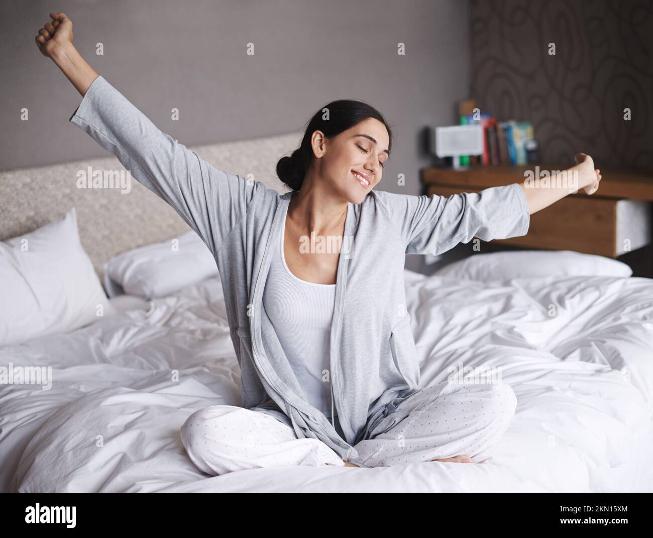 Ready to take on the world. An attractive young woman stretching in bed after waking up Stock ...