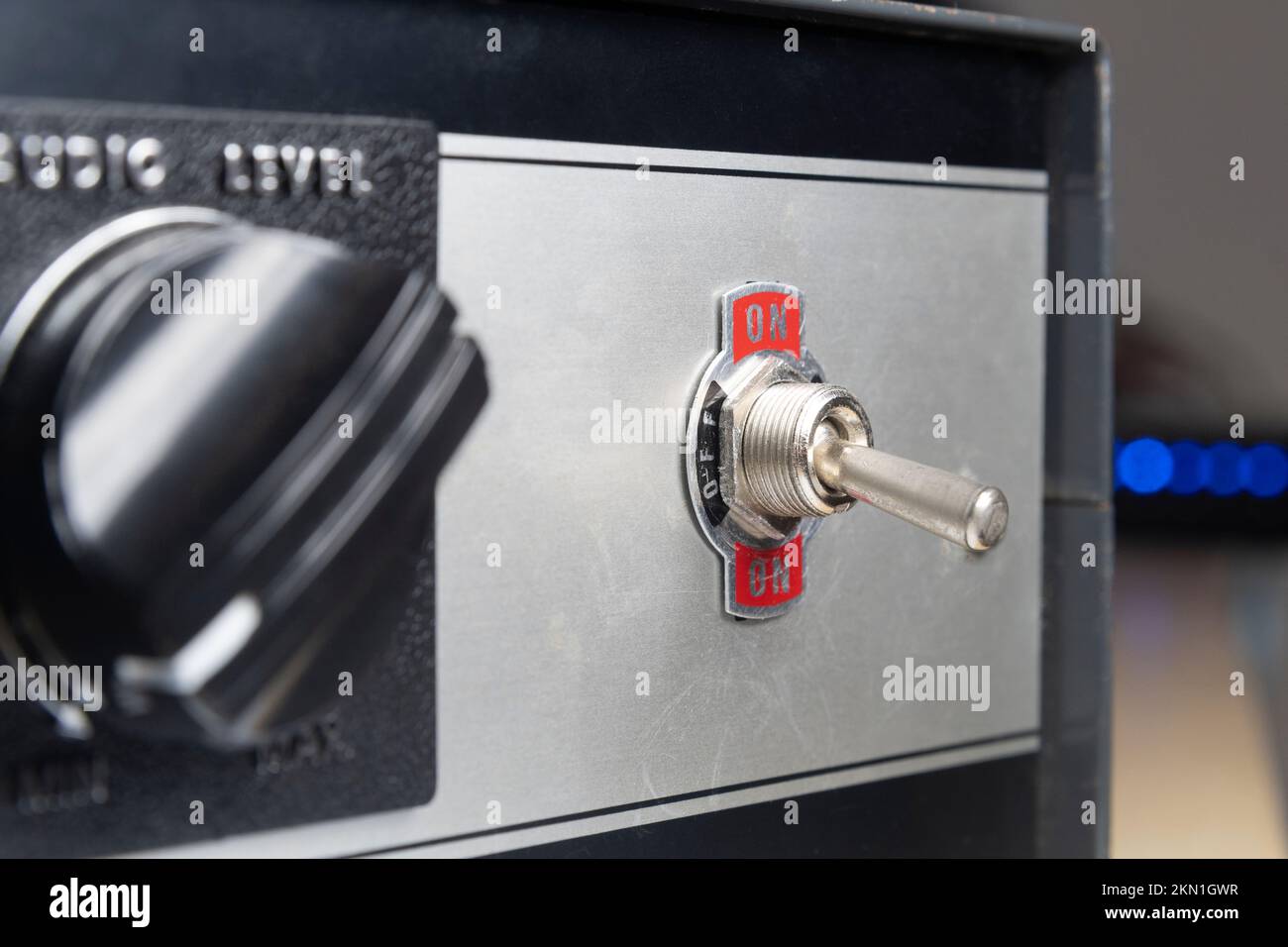 Vintage toggle switch set to on with blue lights in the background ...
