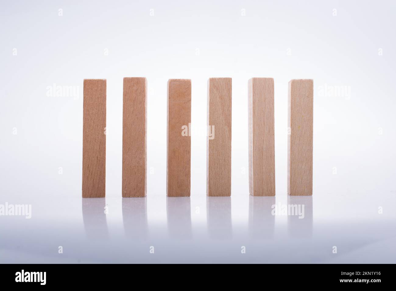 Wooden Domino Blocks in a line on a white background Stock Photo - Alamy