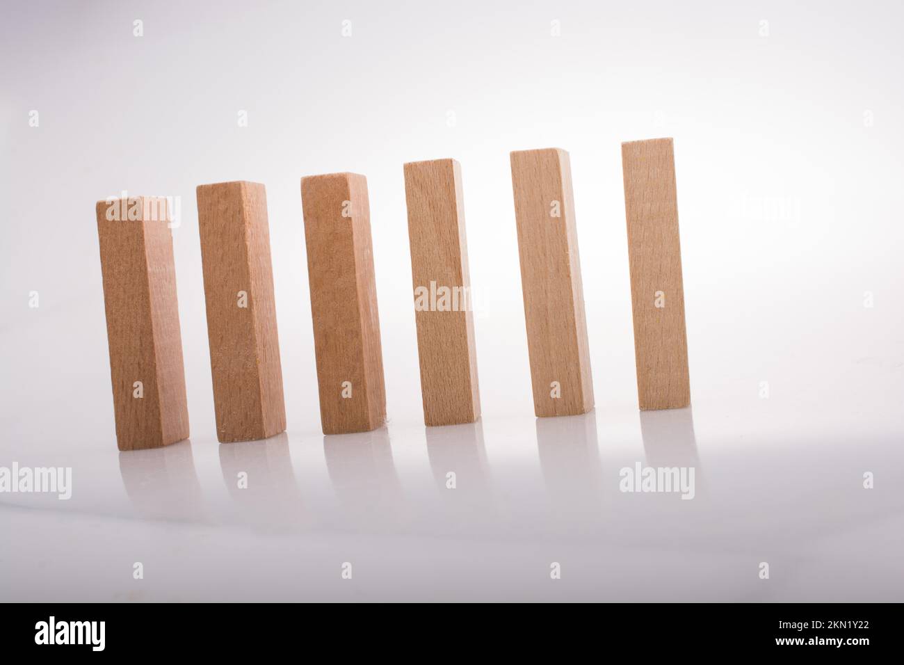 Wooden Domino Blocks in a line on a white background Stock Photo - Alamy