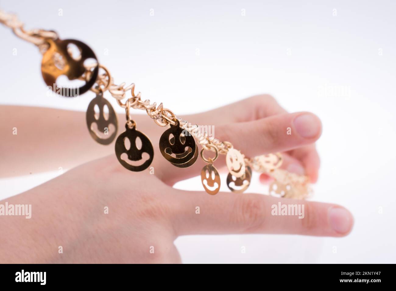 Golden color smileys arrayed on a chain in hand Stock Photo - Alamy
