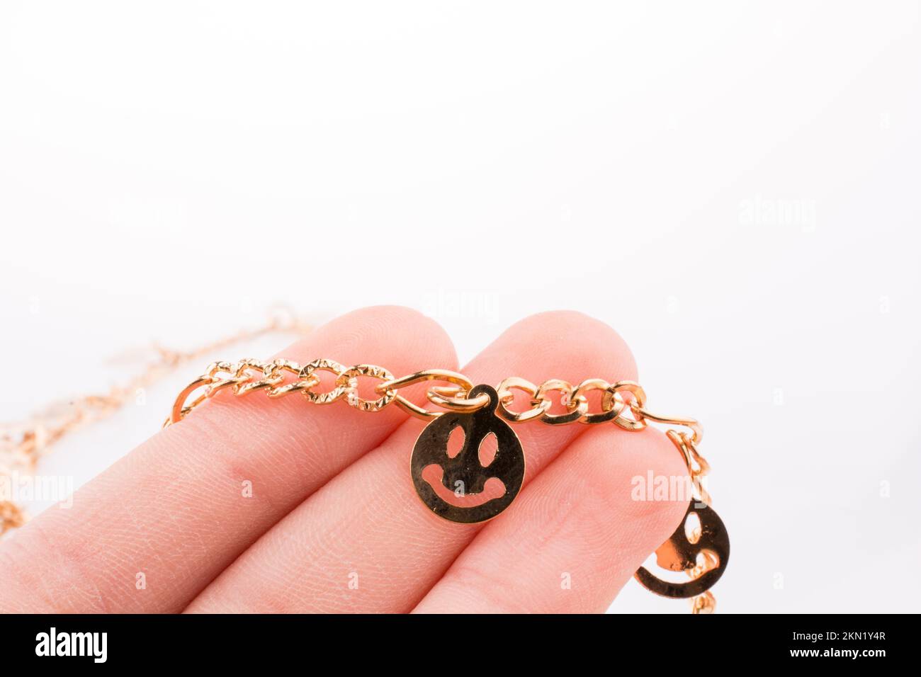 Golden color smileys arrayed on a chain in hand Stock Photo - Alamy