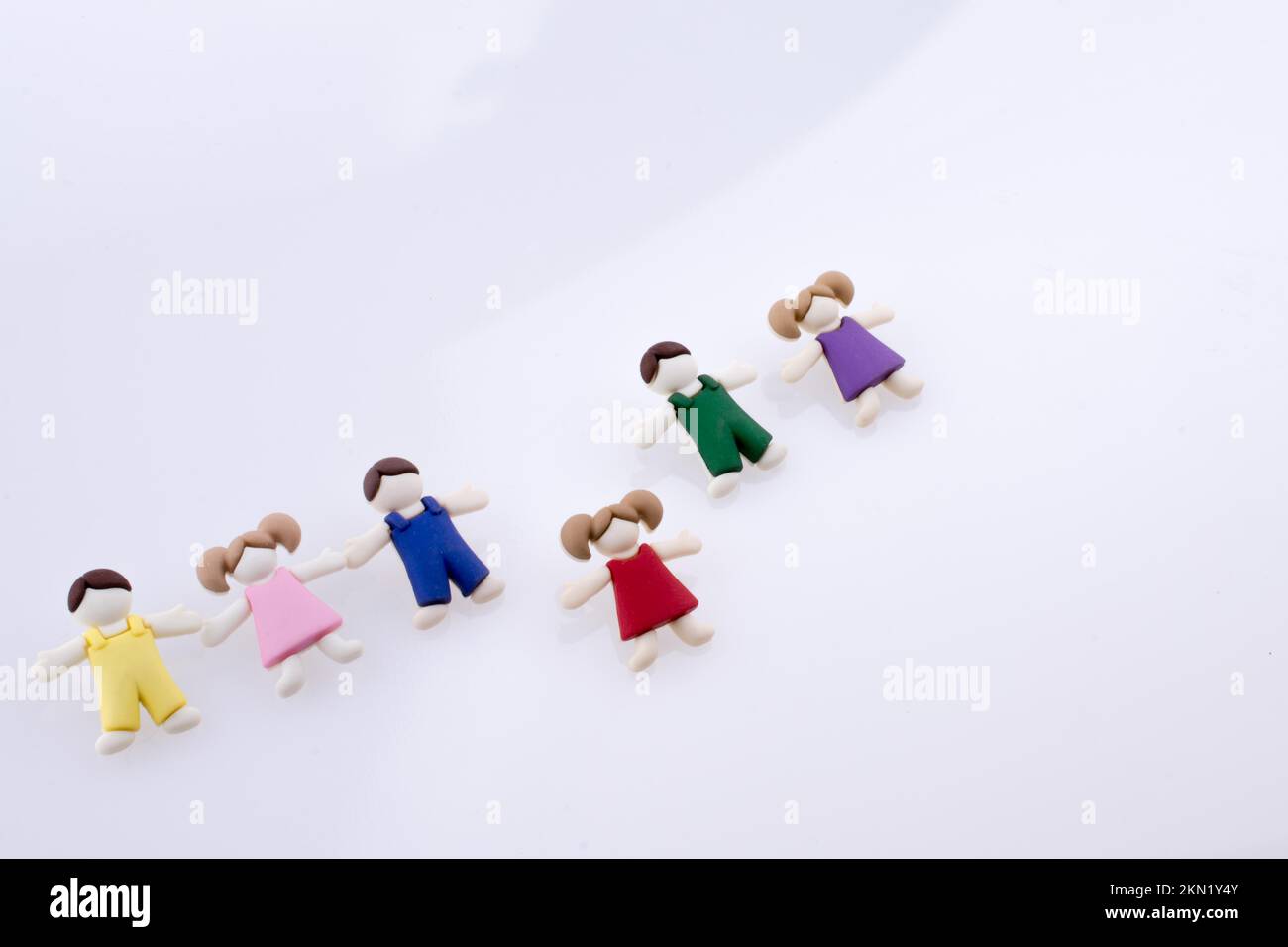 Colorful dressed children figures on a white background Stock Photo - Alamy