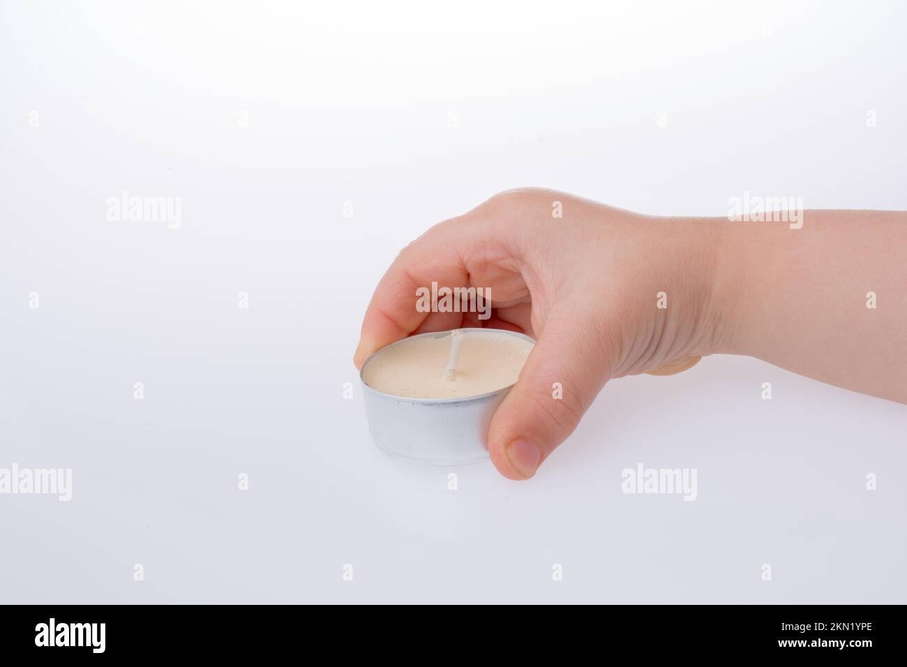 White color small Candle in hand on a white background Stock Photo - Alamy