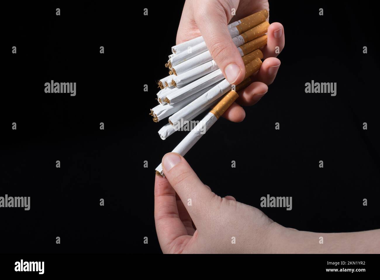 Hand is giving out bundle of cigarettes on black background Stock Photo ...