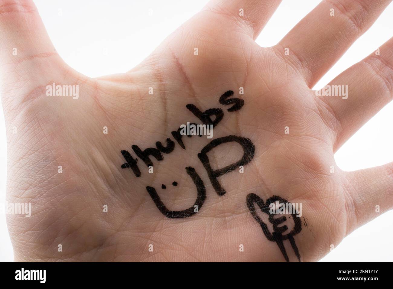 Thumbs up written on hand palm on a white background Stock Photo - Alamy