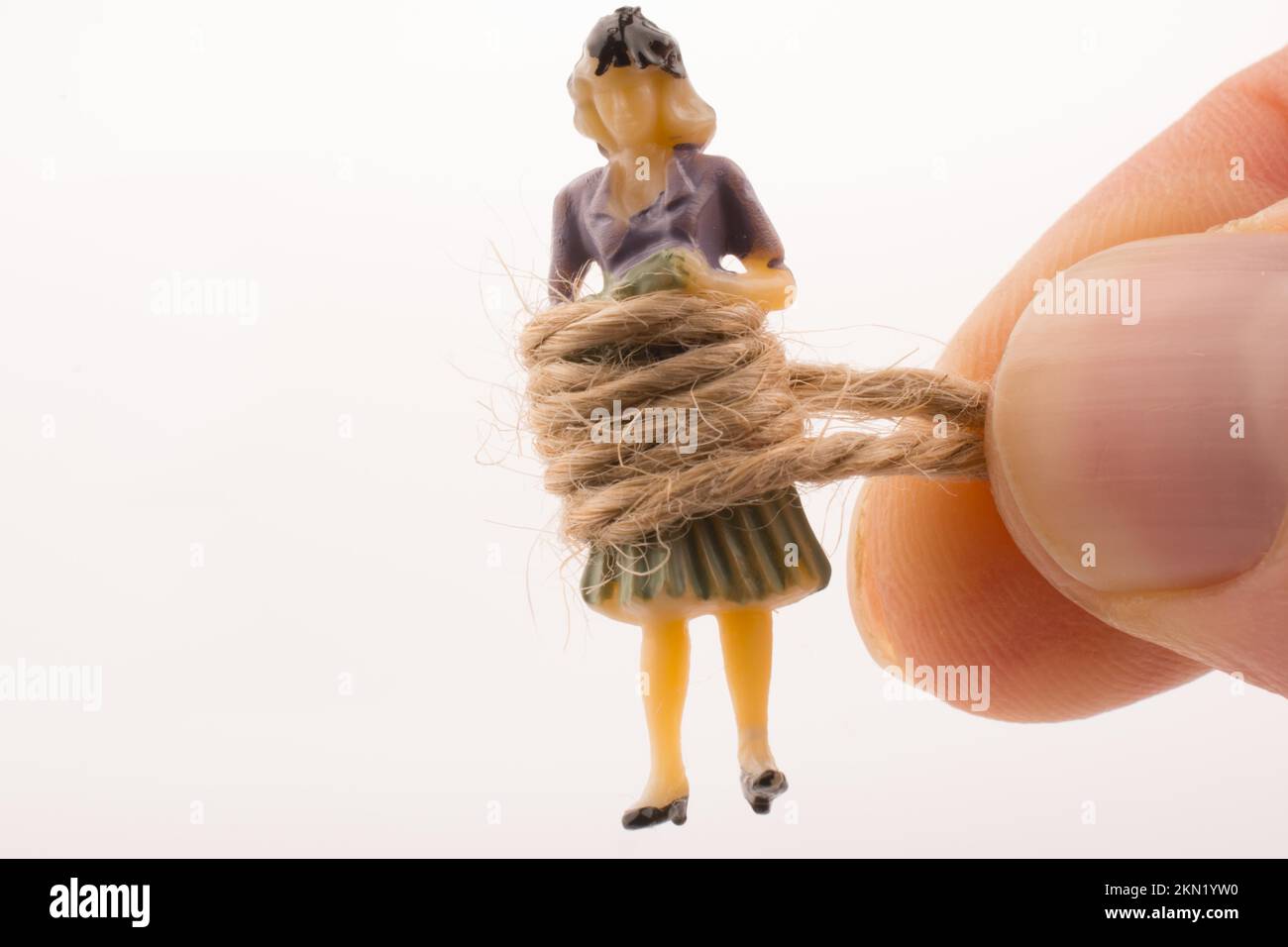 Woman figure in hand tied with a linen thread on a white background ...