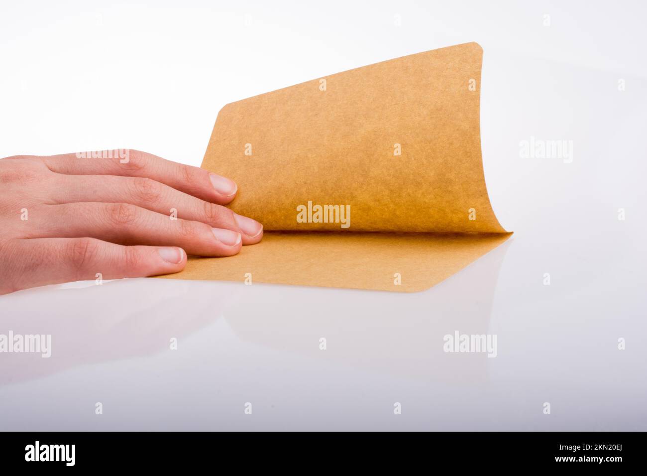 Hand holding a sheet of paper on a white background Stock Photo - Alamy
