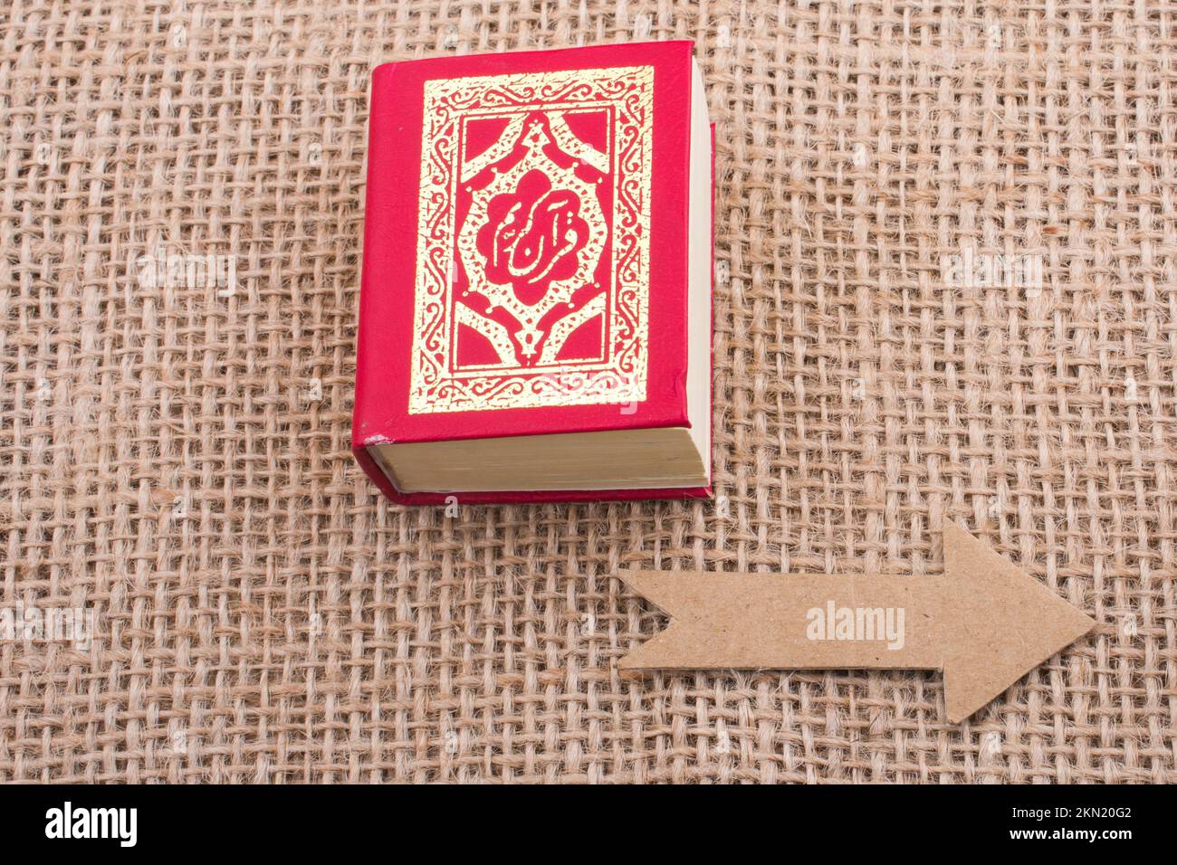Paper arrow and Islamic Holy Book Quran in mini size Stock Photo - Alamy
