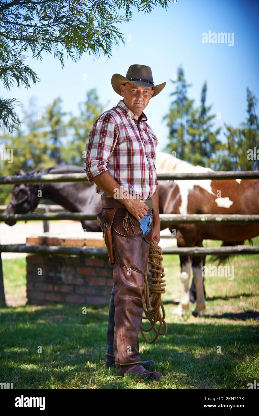 Hes the wrangler of beasts. A mature cowboy outdoors on his farm Stock ...