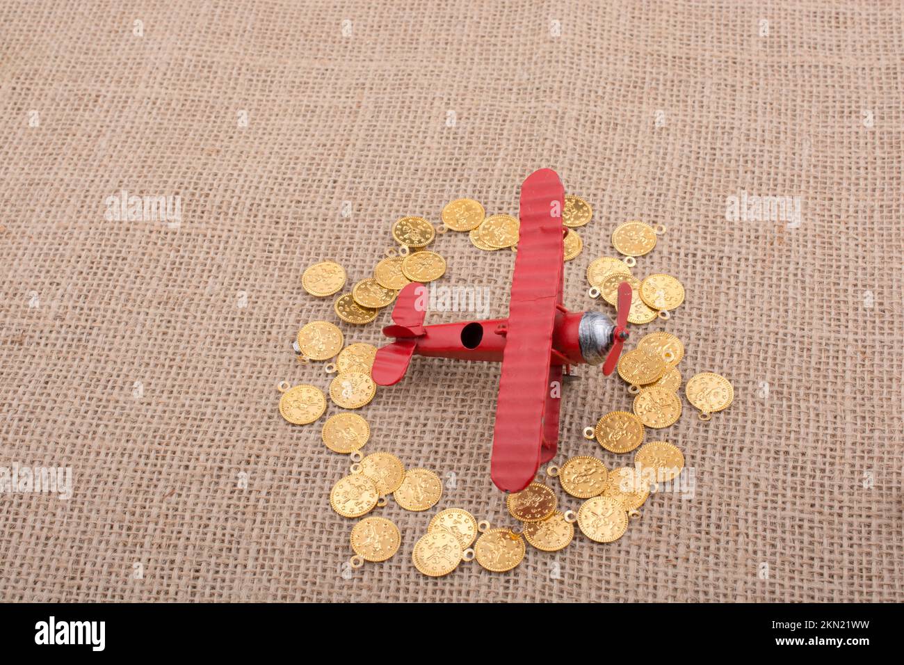 Fake gold coins around the retro model airplane Stock Photo - Alamy