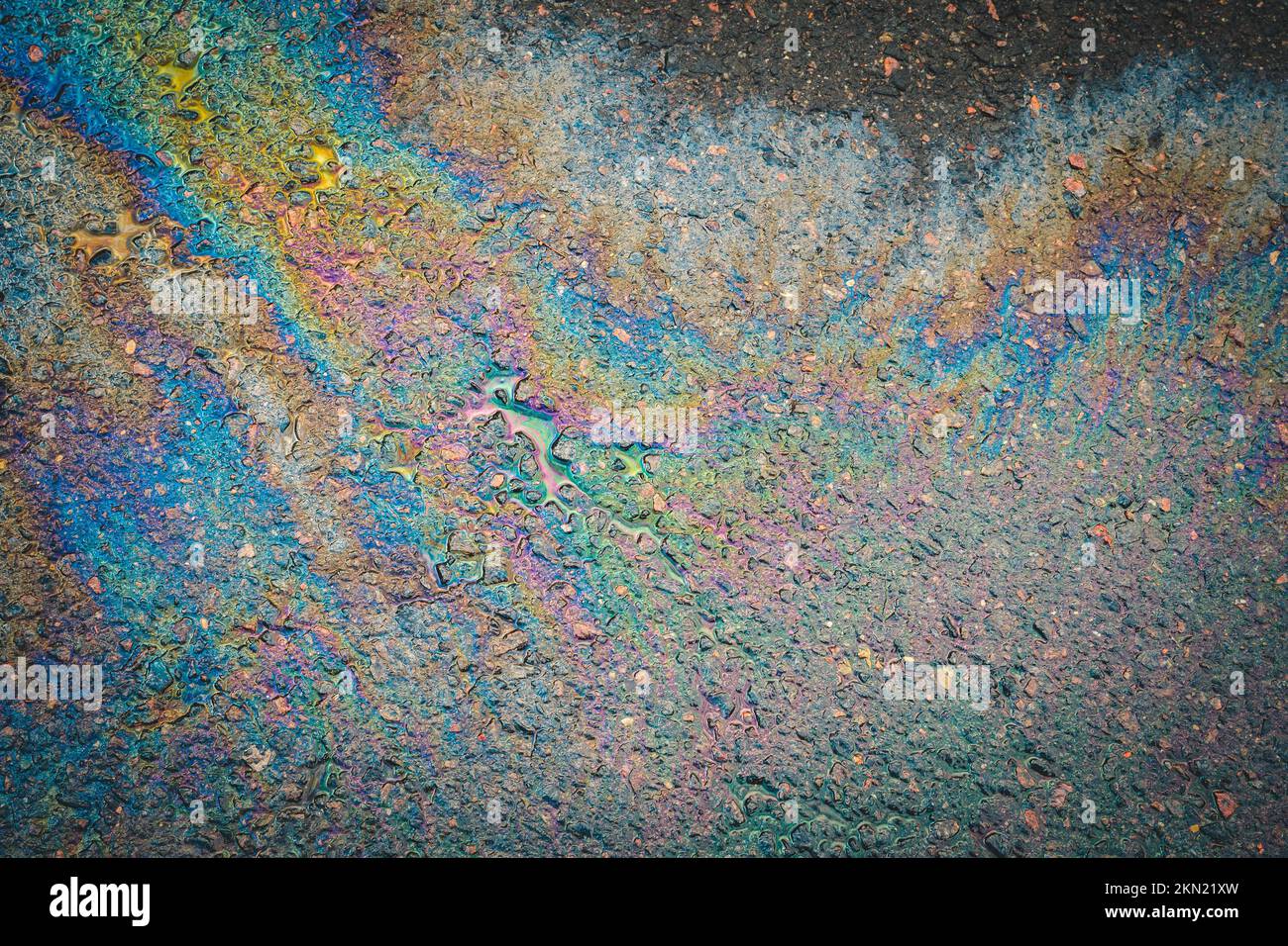 Oil rainbow gasoline spill on asphalt Stock Photo - Alamy
