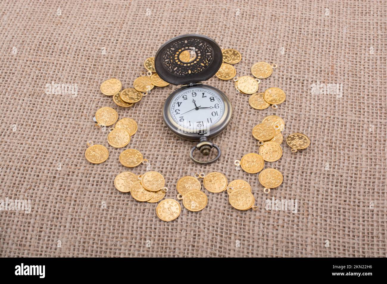 Retro styled pocket watch with fake gold coins around Stock Photo - Alamy