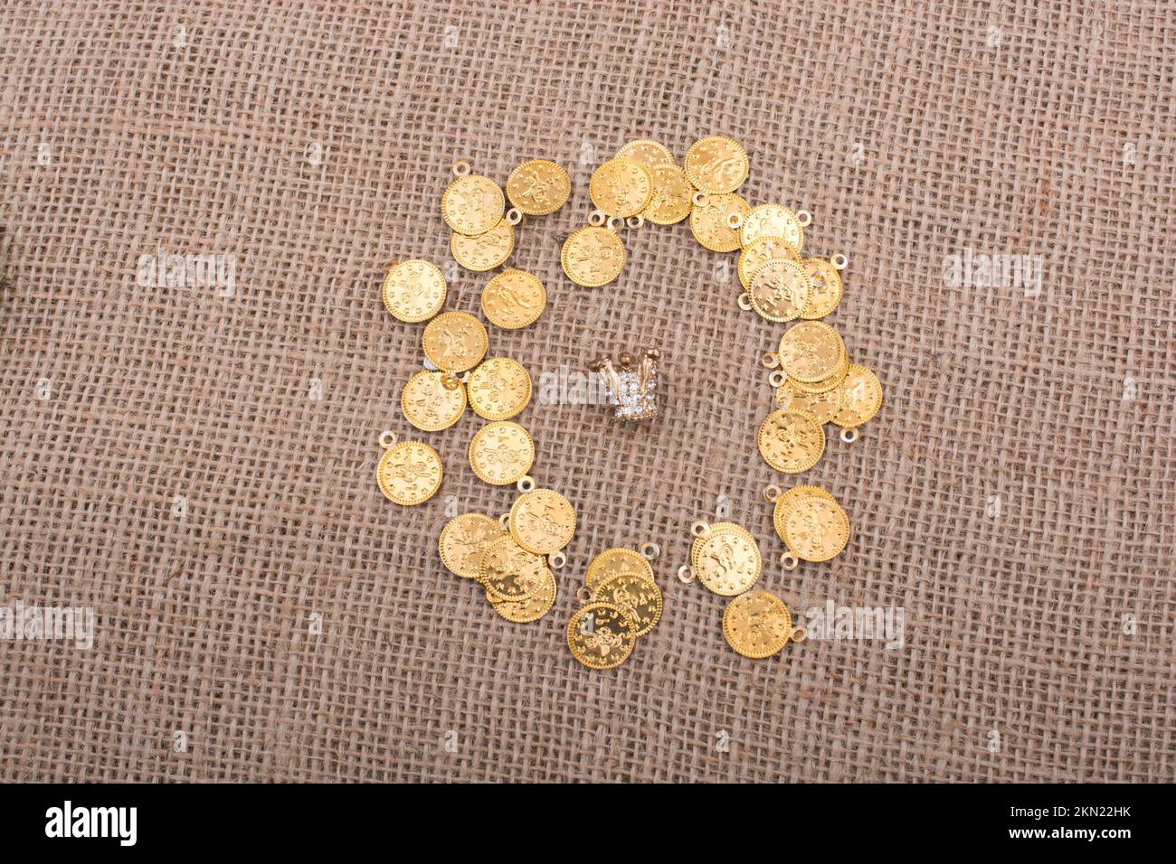 Fake gold coins are around the little model crown Stock Photo - Alamy