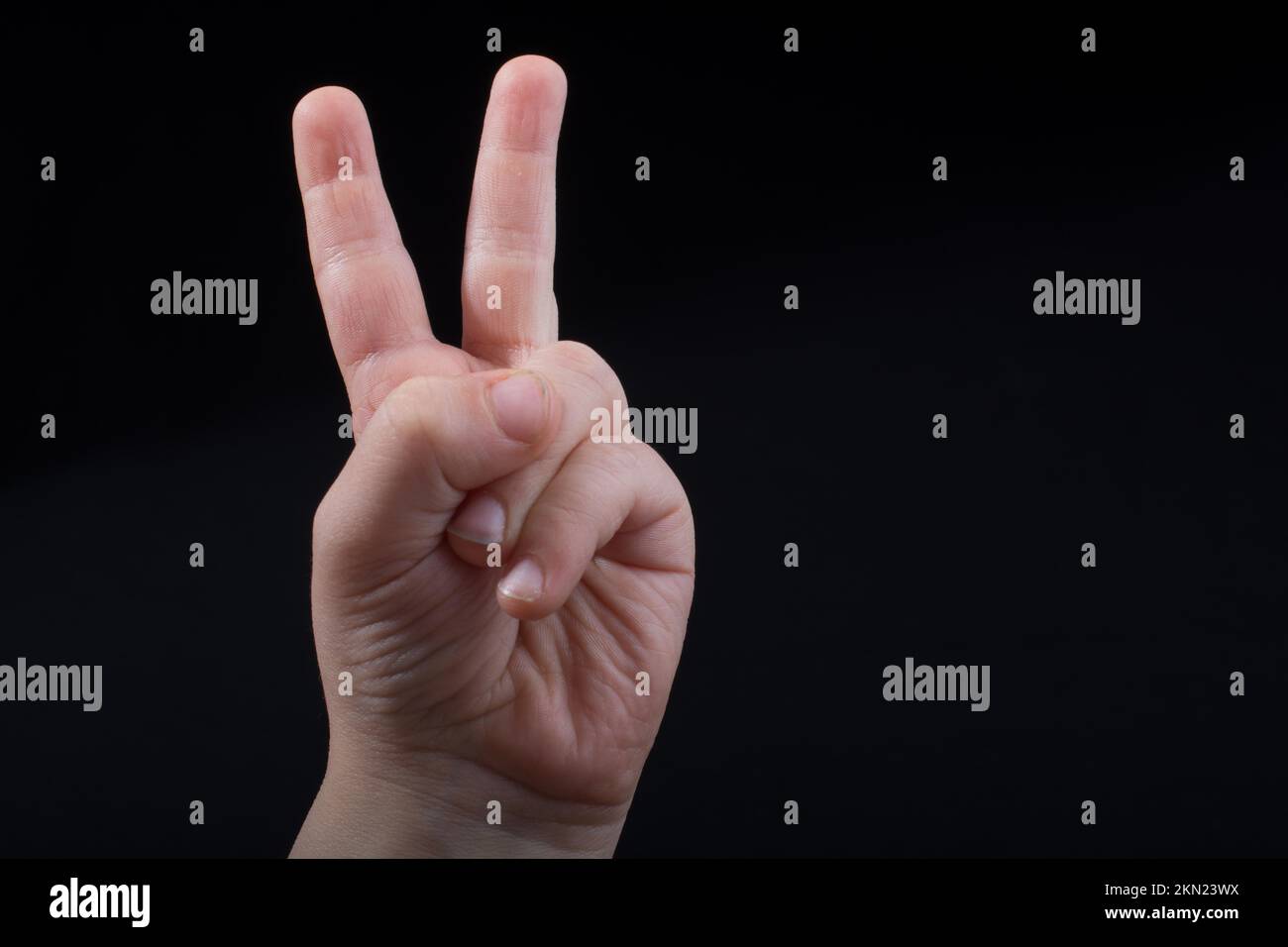 The sign of victory and peace in black background Stock Photo - Alamy