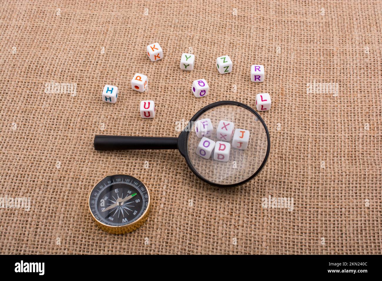 Compass and colorful letter cubes behind a magnifying glass Stock Photo ...