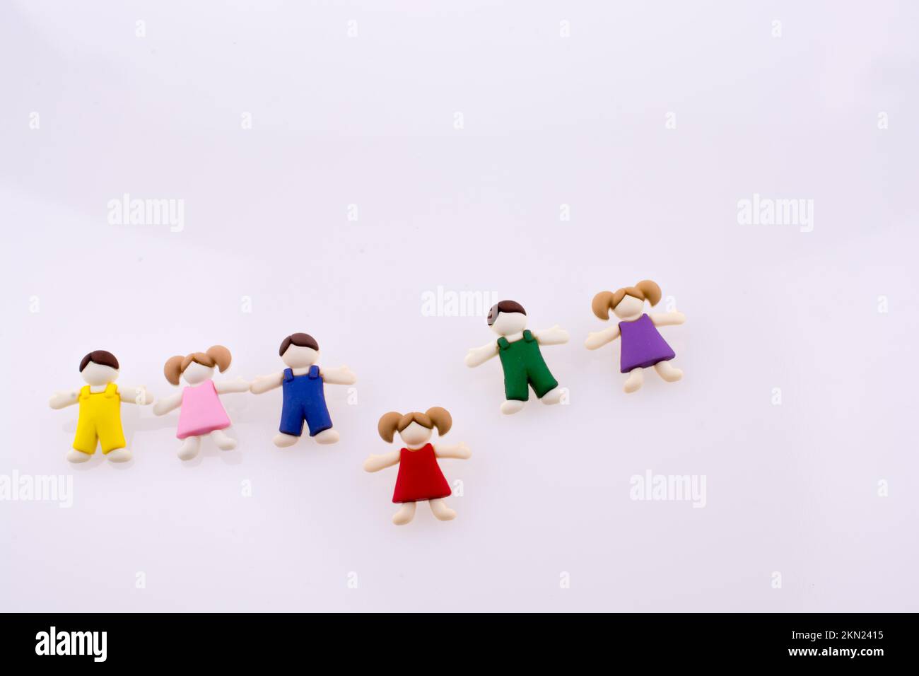 Colorful dressed children figures on a white background Stock Photo - Alamy