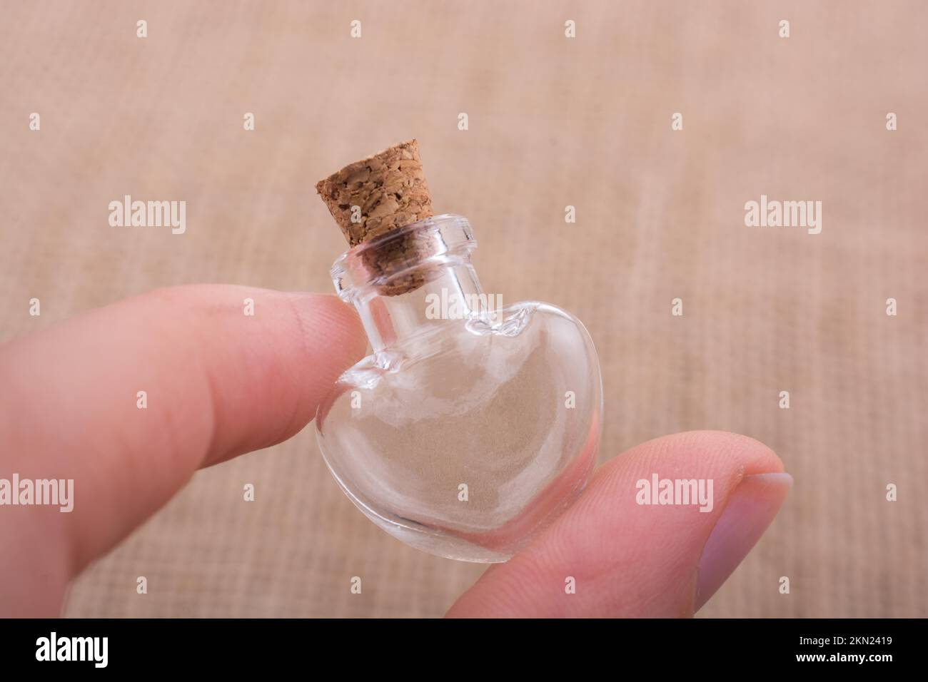 Heart shaped glass bottle is held in hand Stock Photo - Alamy
