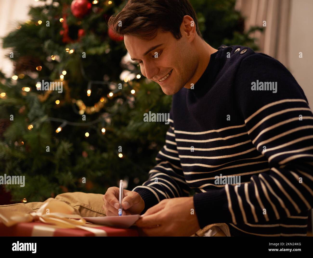 Writing out name tags. a handsome young man getting ready for Christmas ...