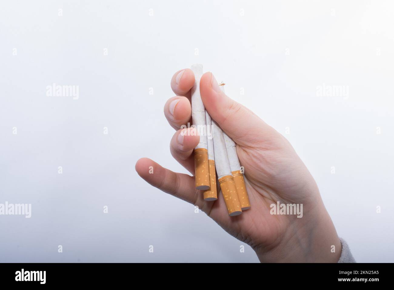 Hand is holding bundle of cigarettes on white background Stock Photo ...