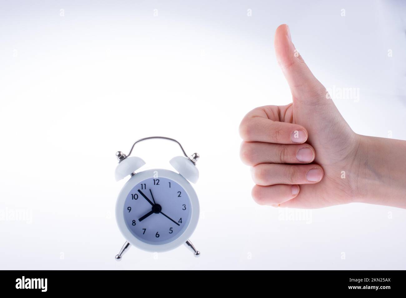 Alarm clock in hand on a white background Stock Photo - Alamy