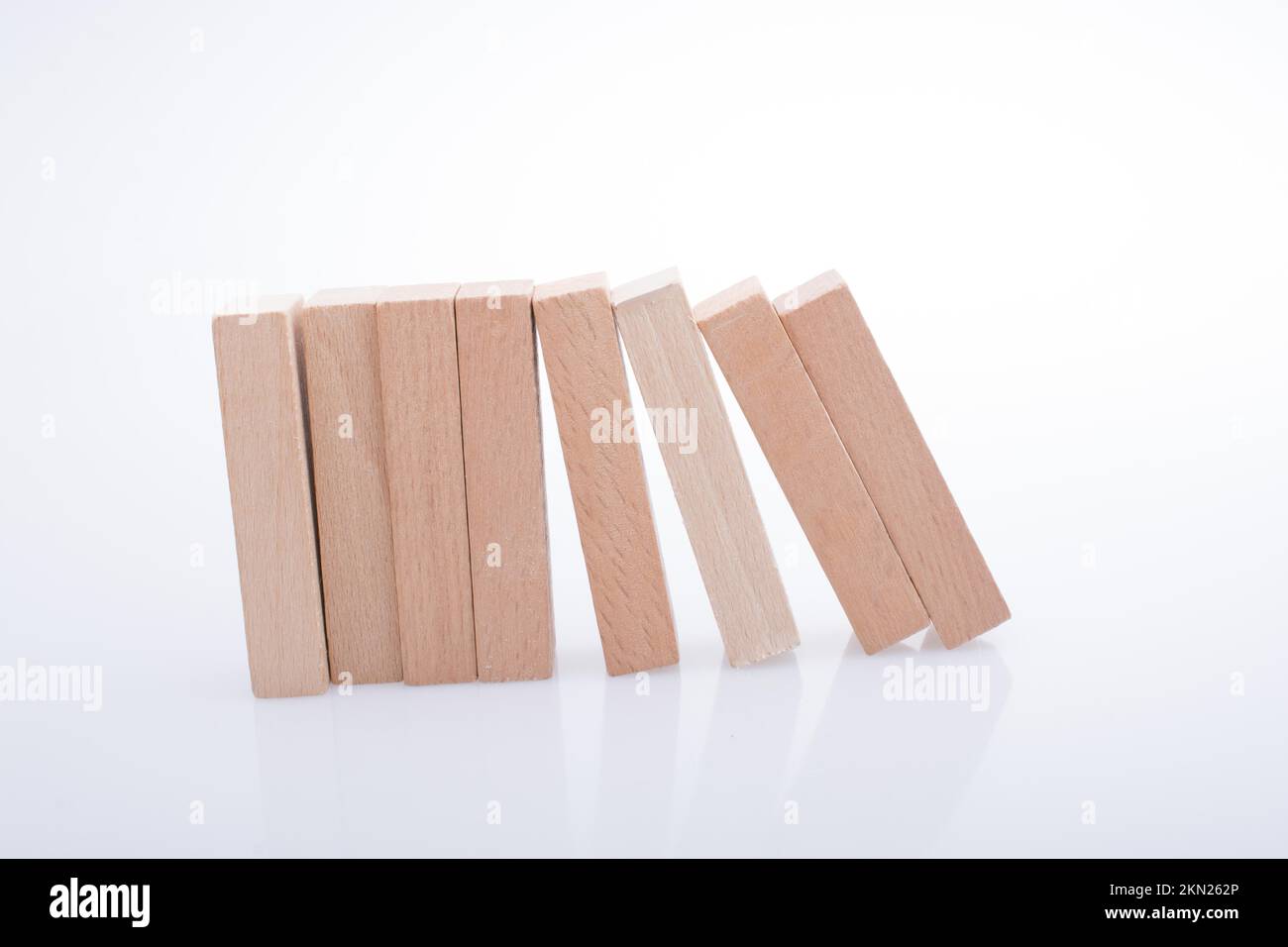 Wooden Domino Blocks in a line on a white background Stock Photo - Alamy
