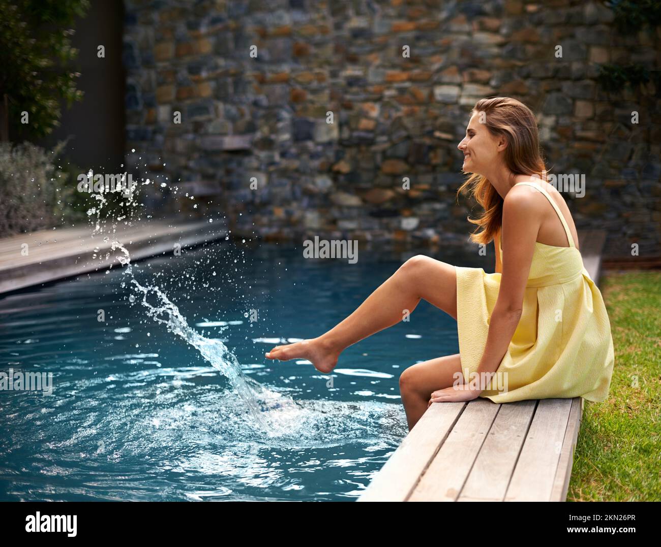Time for a splash. Beautiful woman in a yellow dress at the pool Stock ...