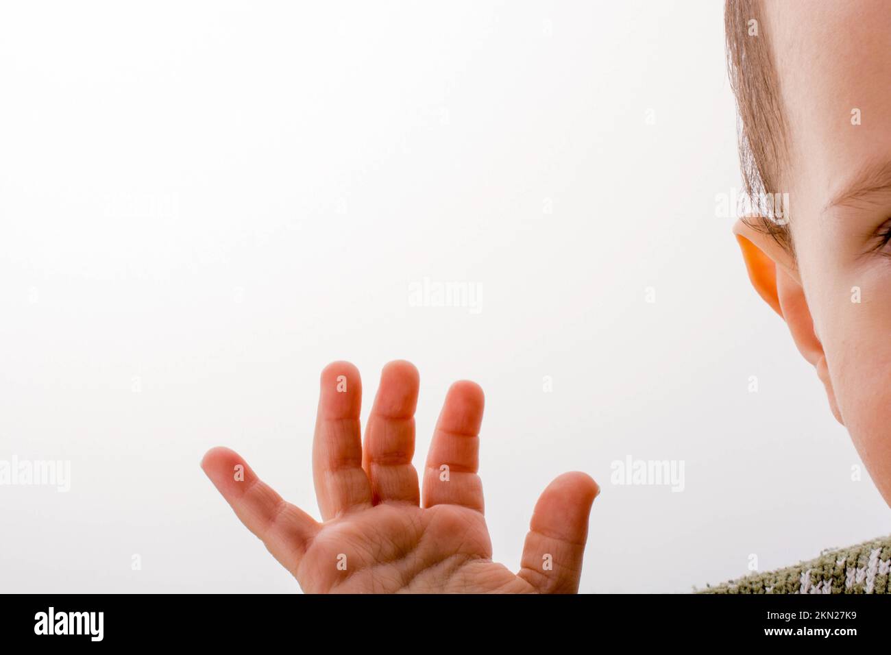 Baby holding his hand up on white background Stock Photo - Alamy