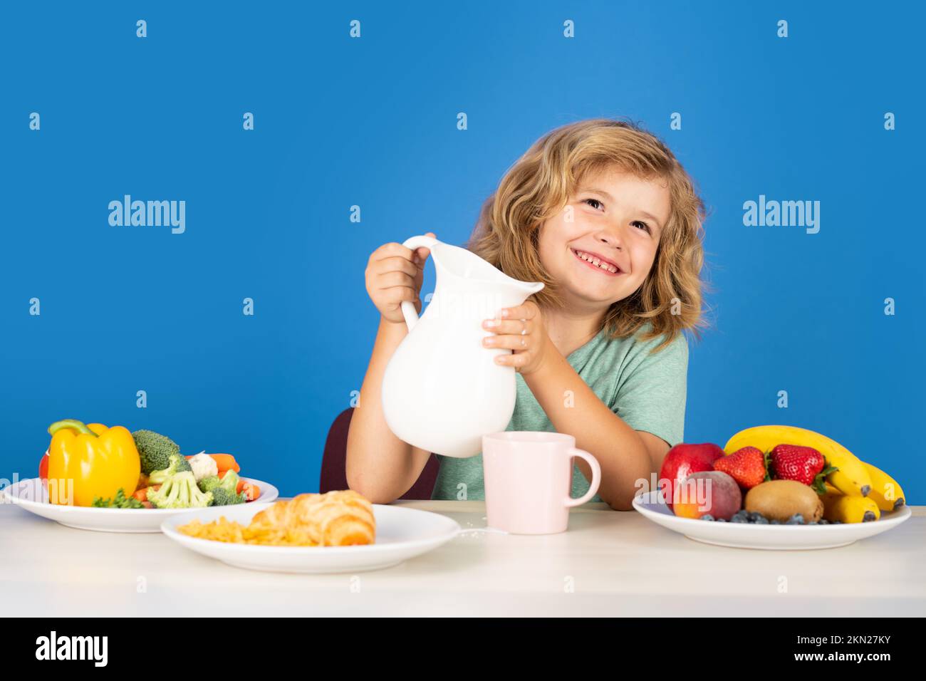 Kid pours dairy milk. Healthy child pours milk from jug Stock Photo - Alamy