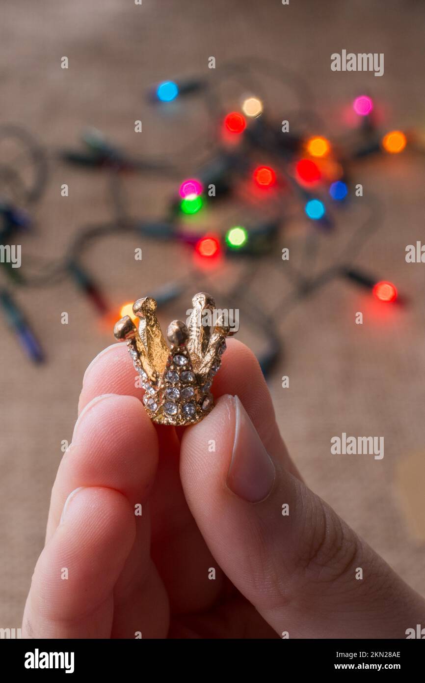 Little crown in hand with colorful lights behind Stock Photo - Alamy