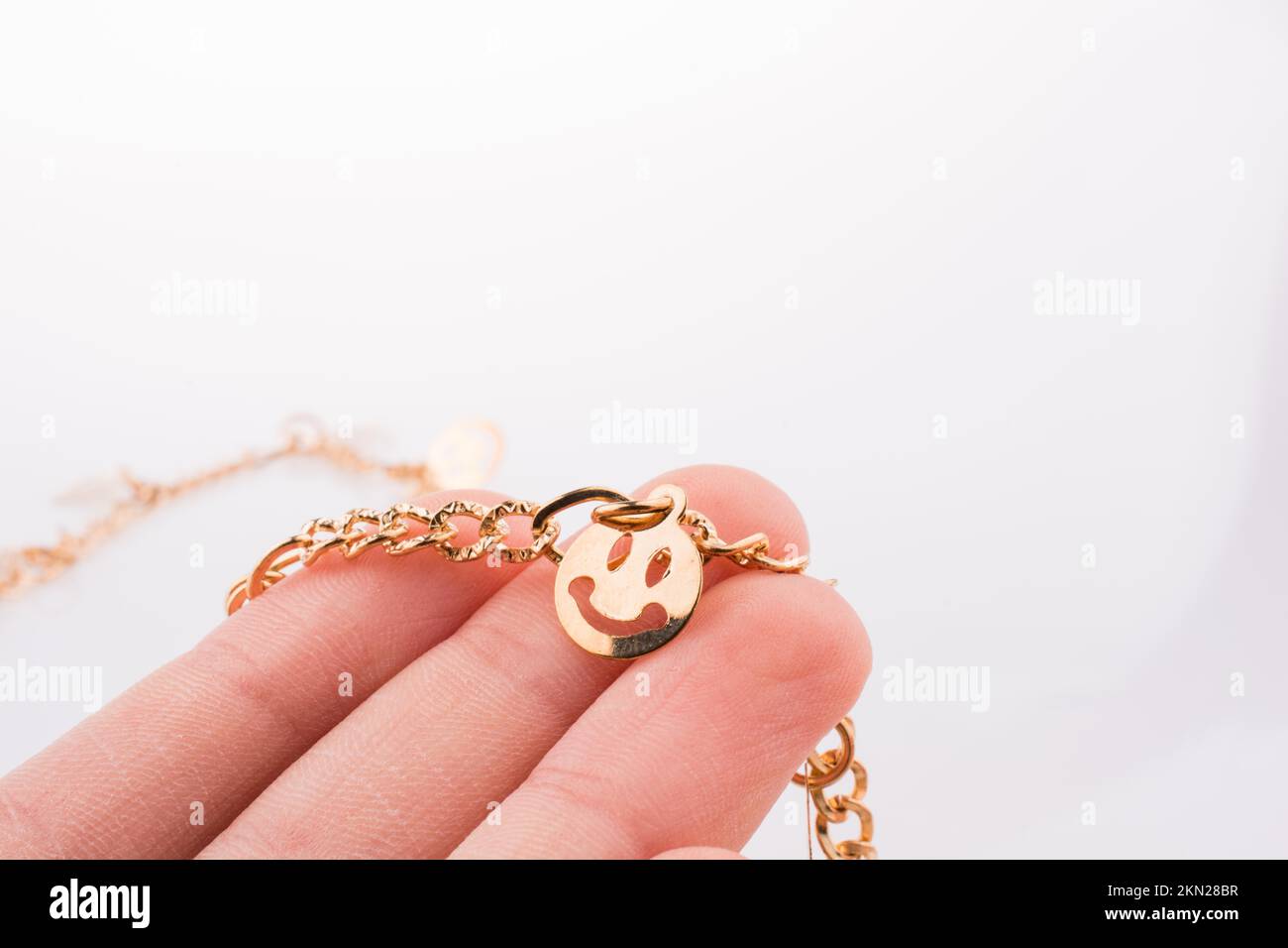 Golden color smileys arrayed on a chain in hand Stock Photo - Alamy