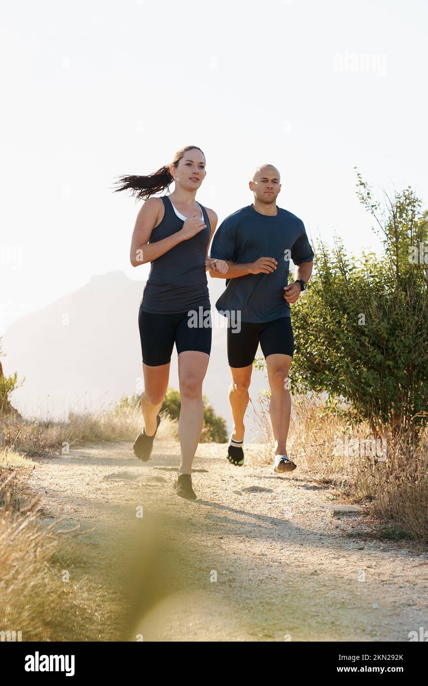 Staying fit thanks to their daily run. a young couple running along a ...