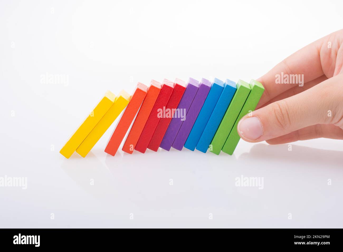 Hand holding color dominoes on a white background Stock Photo - Alamy