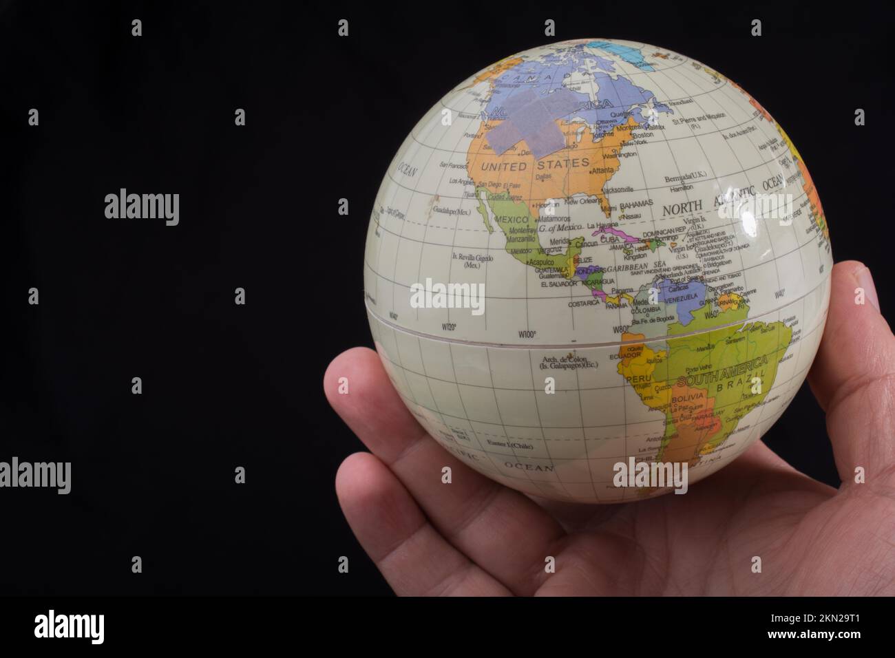 Hand holding a globe with map on it Stock Photo - Alamy