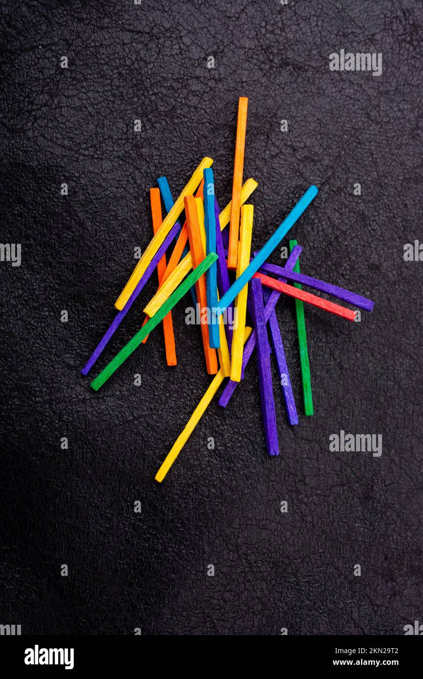 Beautiful coloured wooden sticks for creativity on black background ...