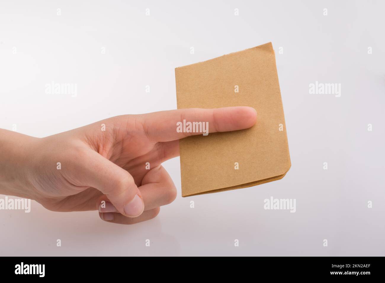 Hand holding a brown color sheet of paper on a white background Stock ...