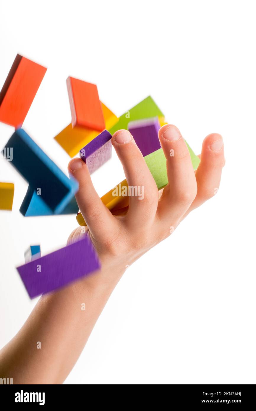Falling colorful domino onto a hand Stock Photo - Alamy