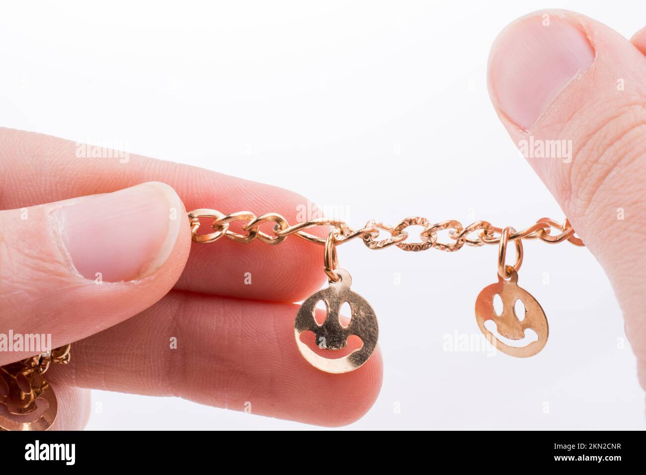Golden color smileys arrayed on a chain in hand Stock Photo - Alamy