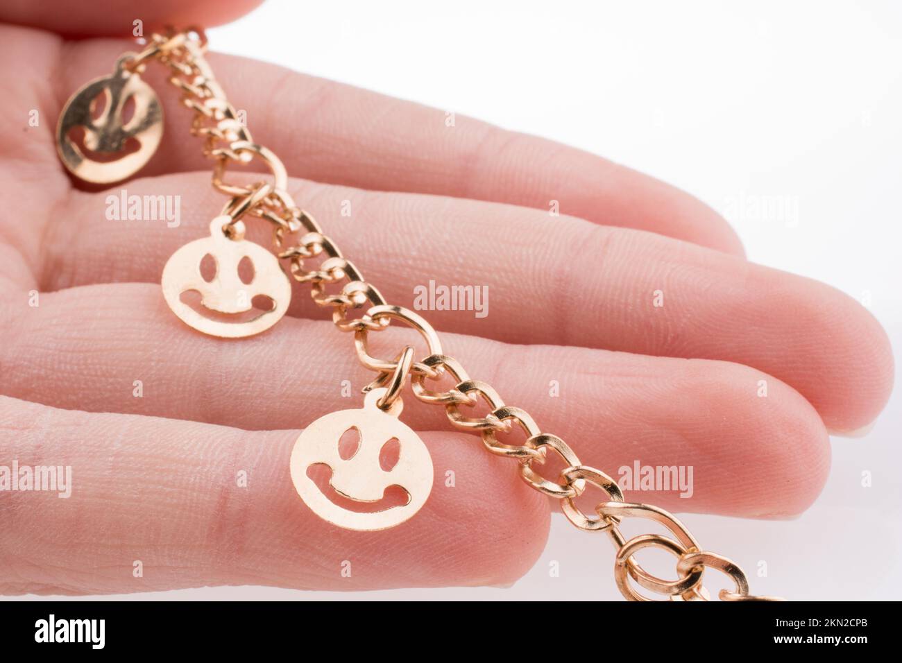 Golden color smileys arrayed on a chain in hand Stock Photo - Alamy