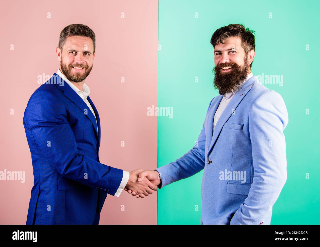 Men in suits businessmen hold hands in handshake. Businessmen with ...