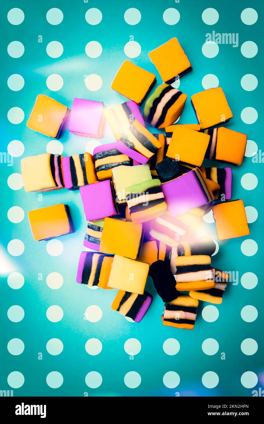 Retro still life composite of colorful candies on blue patterned table ...