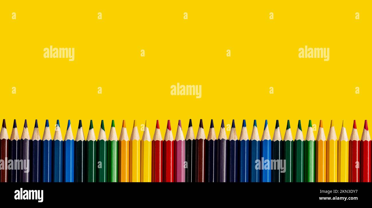 Colored pencils border on yellow background. Banner with copy space ...