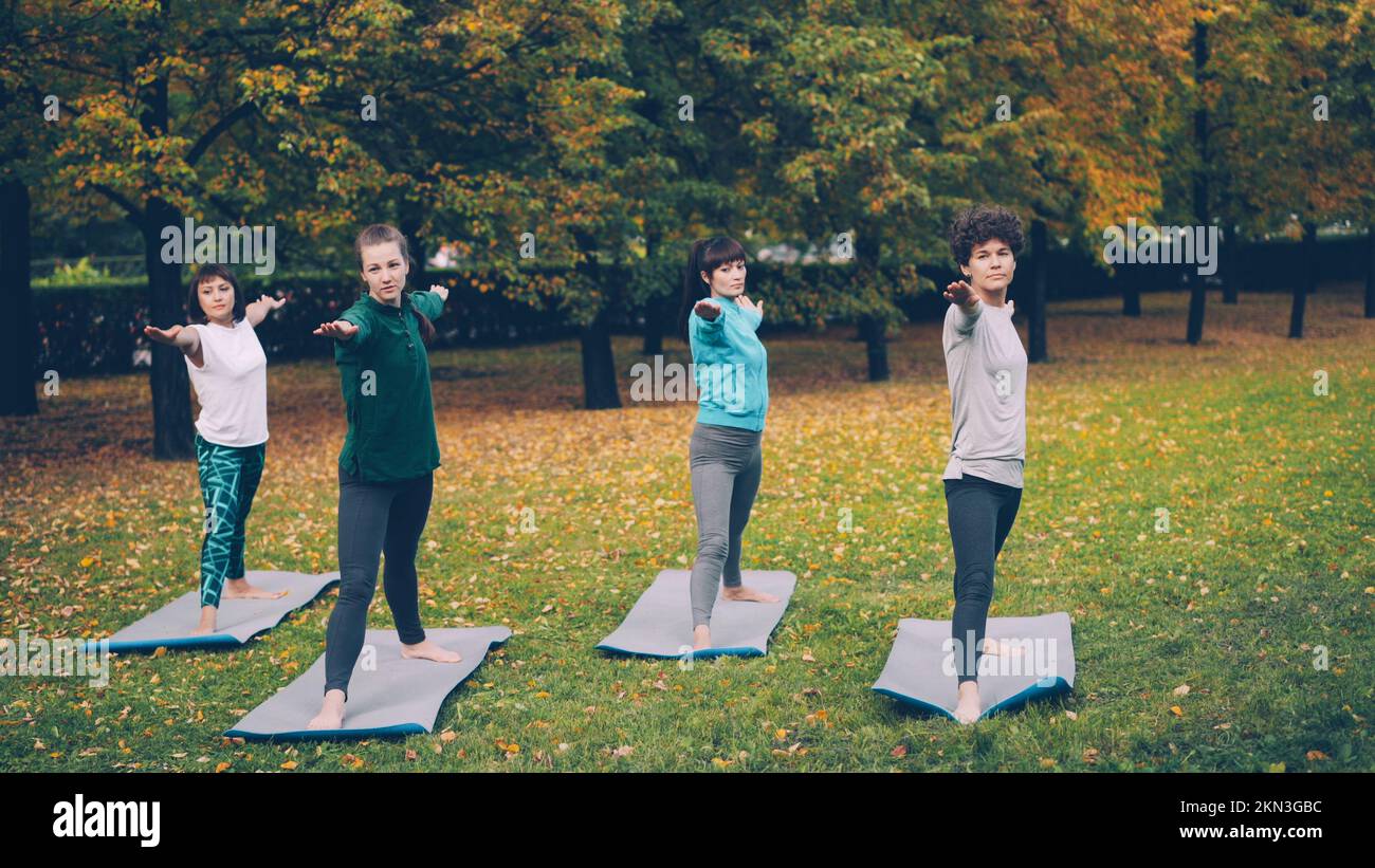 Young women are doing yoga standing in warrior pose Virabhadrasana then ...